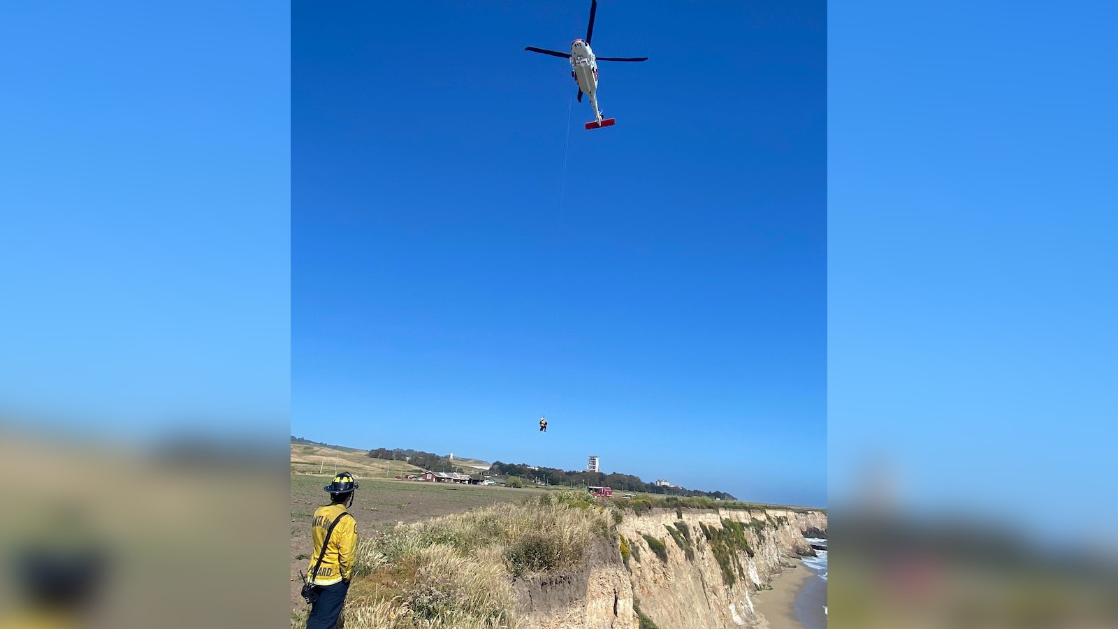Stranded kite surfer rescued after writing 'HELP' out of rocks in the ...